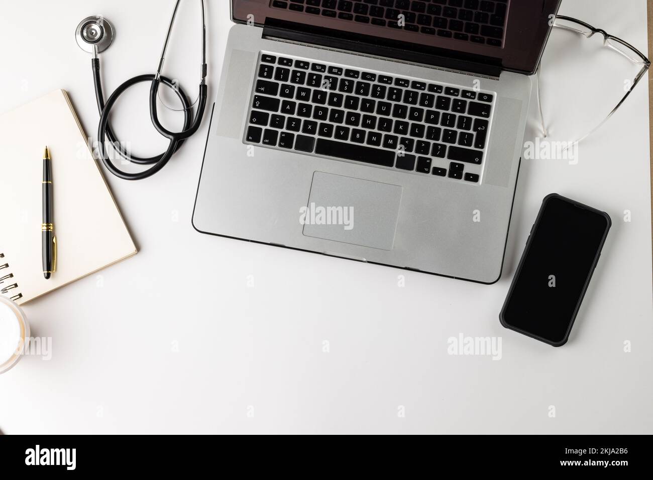 Composition of stethoscope with laptop, smartphone, pen and notebook ...