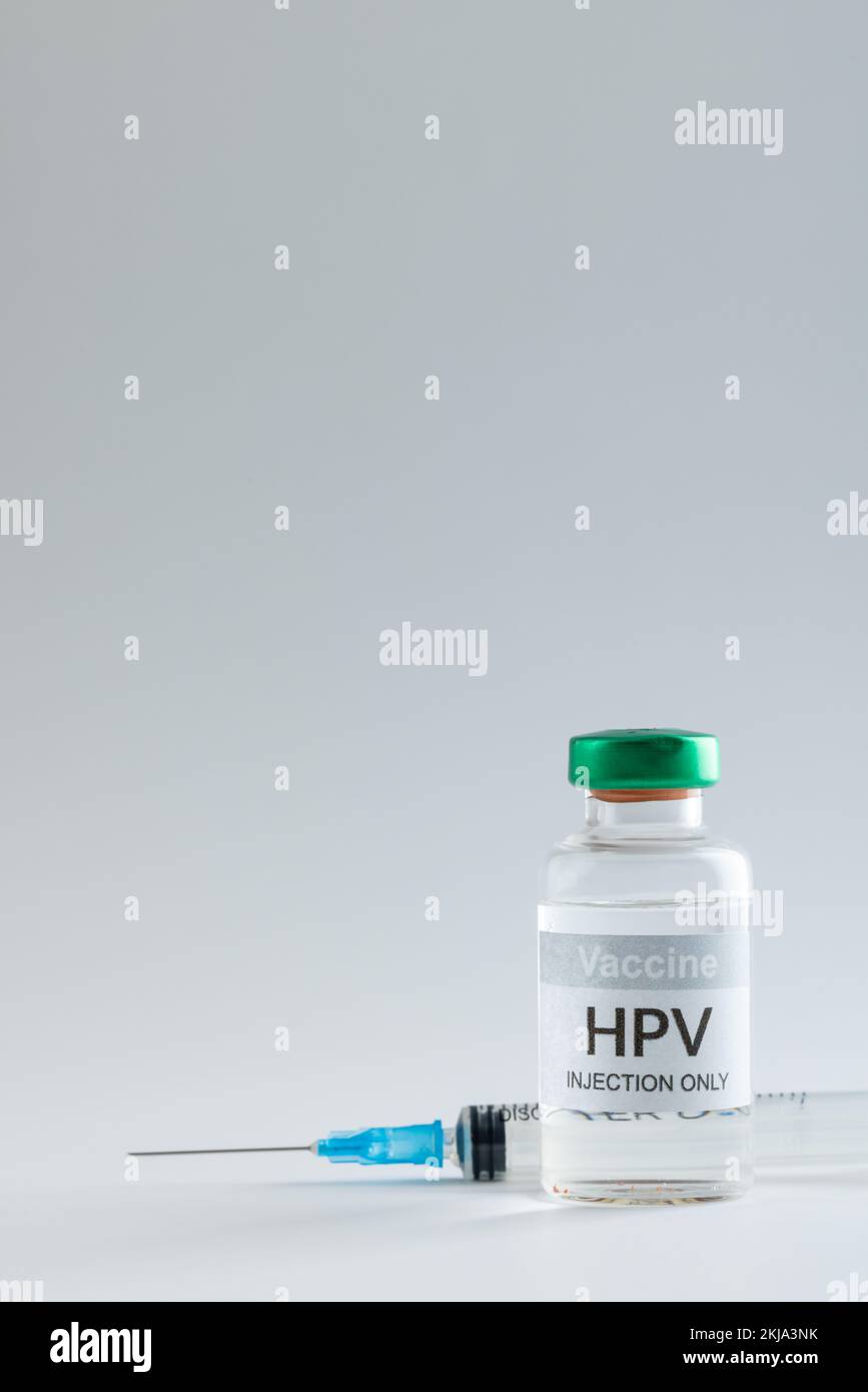 Vertical composition of hpv vaccine vial and syringe on grey background ...