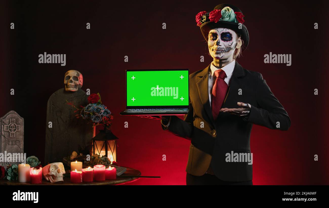 Scary female model holding laptop with greenscreen display, showing ...