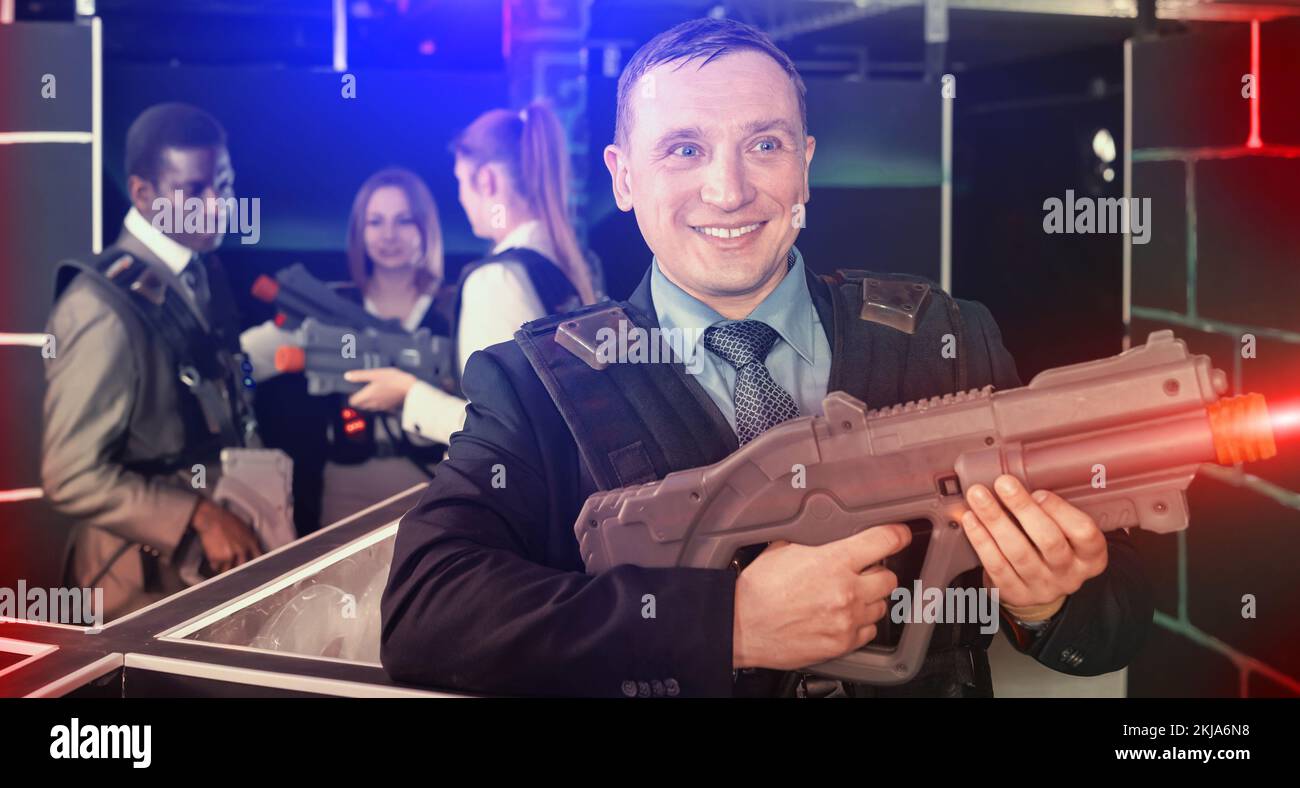 Adult man and his colleagues in laser tag room Stock Photo - Alamy