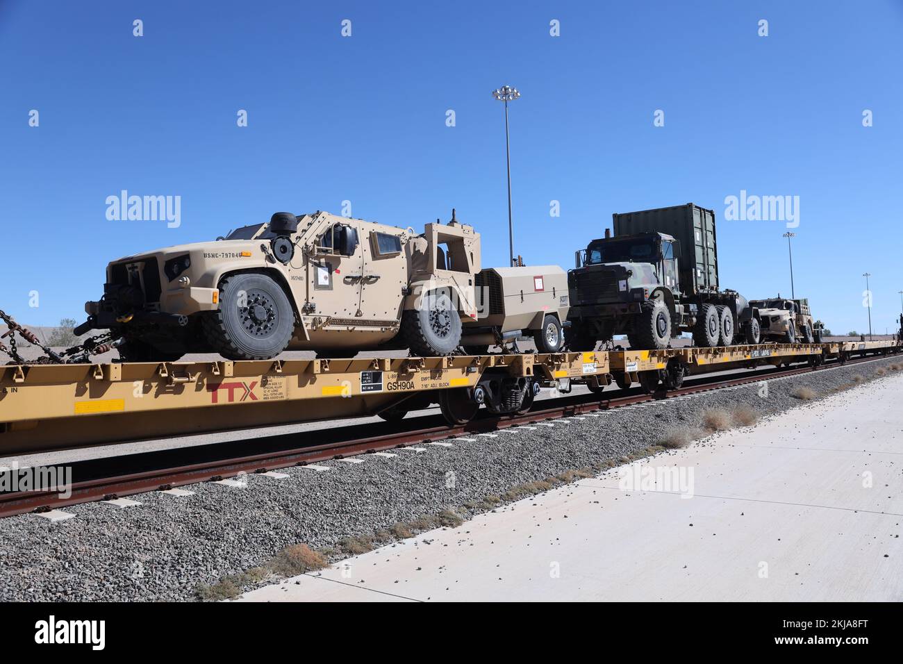 U.S. Marine Corps vehicles are chained down on train cars during ...