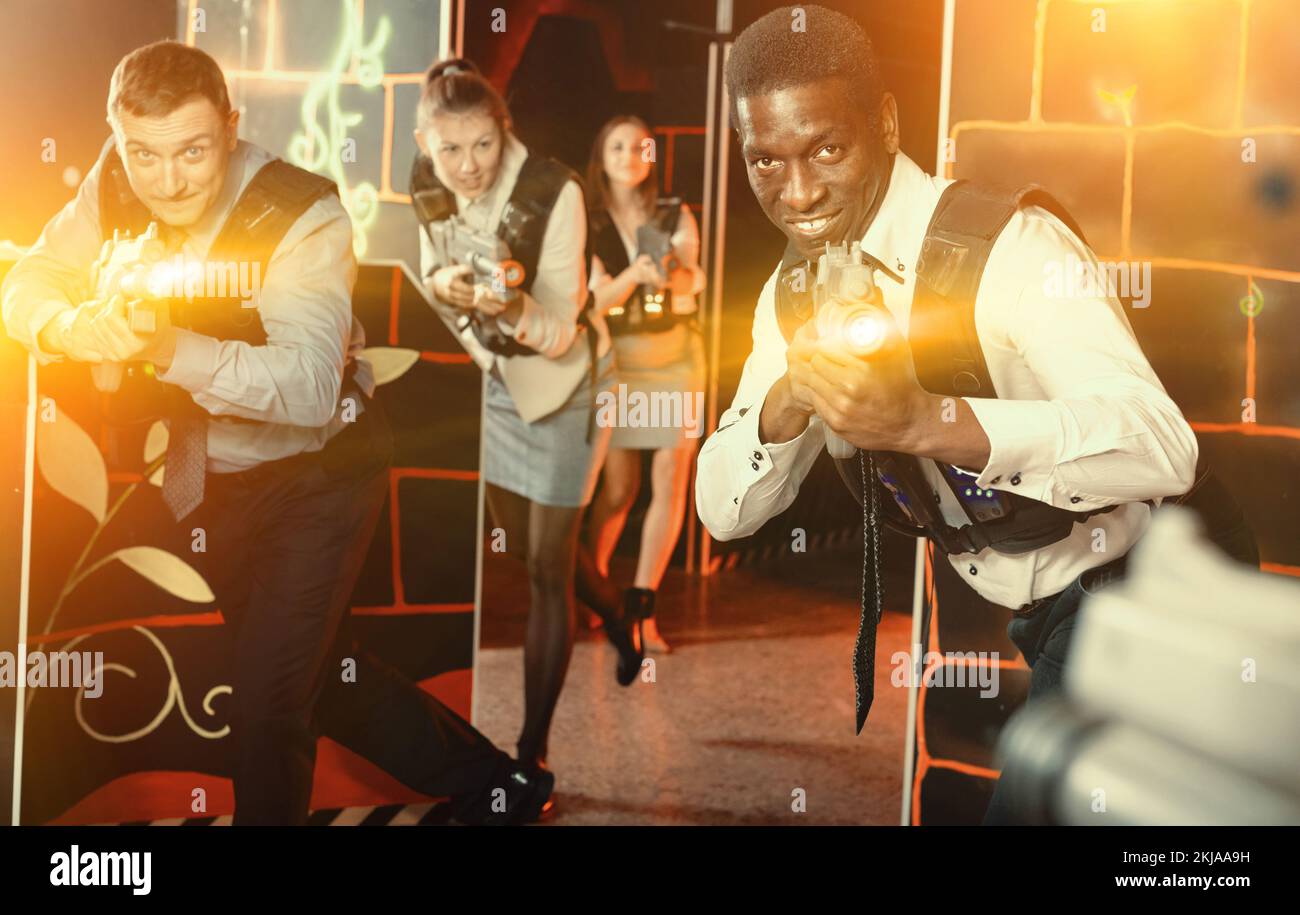 Men and women in business suits playing laser tag emotionally in Stock ...