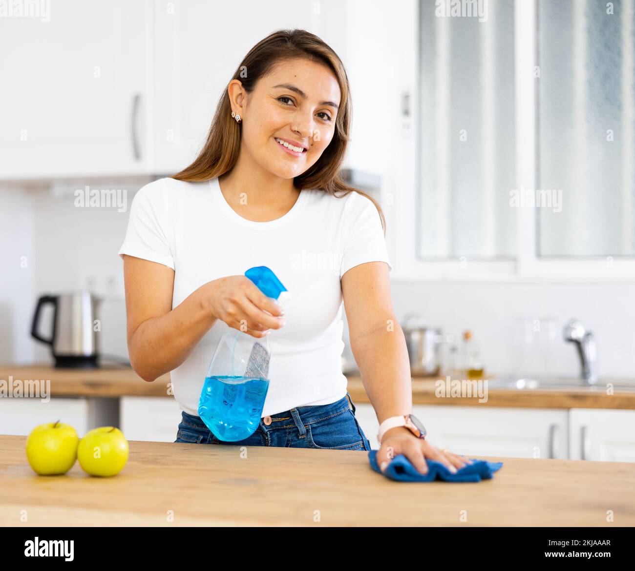 Positive young latin american woman cleaning kitchen countertop Stock ...