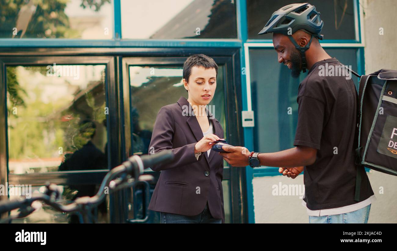 Female client paying for food delivery order with credit card, woman ...