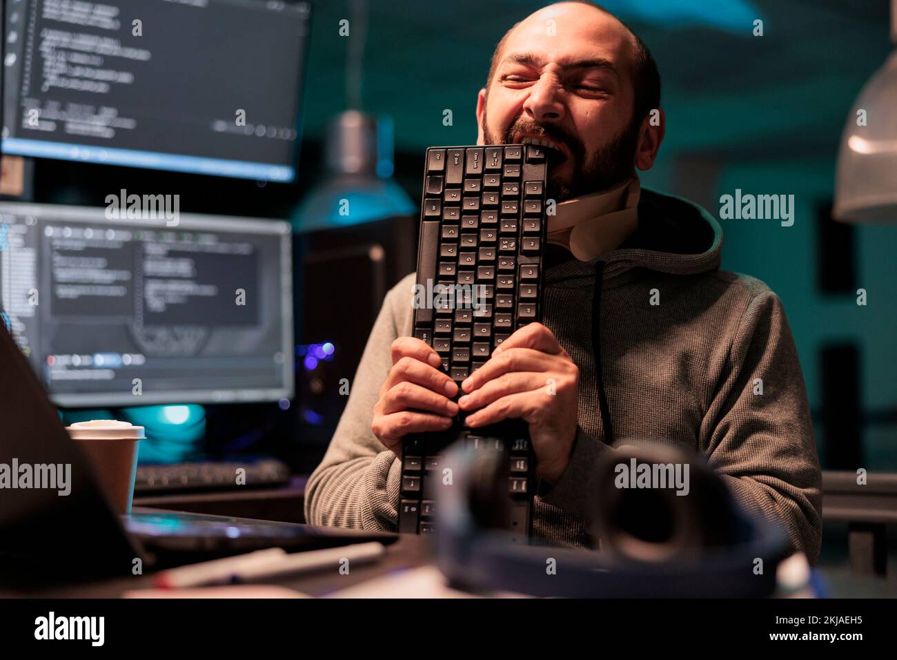 Frustrated programmer wearing cervical neck collar and biting on ...