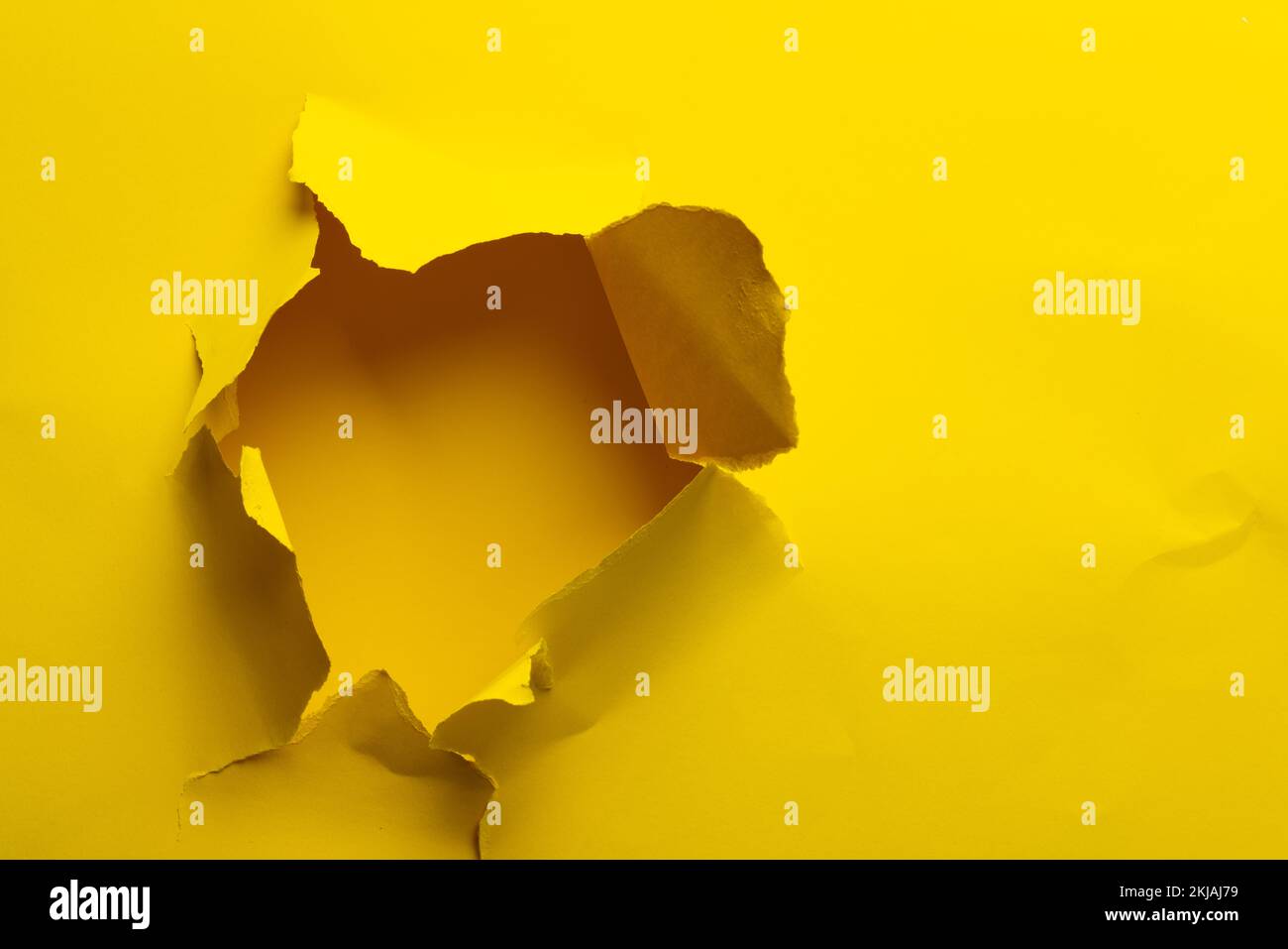 Ripped up piece of yellow paper with copy space on yellow background ...