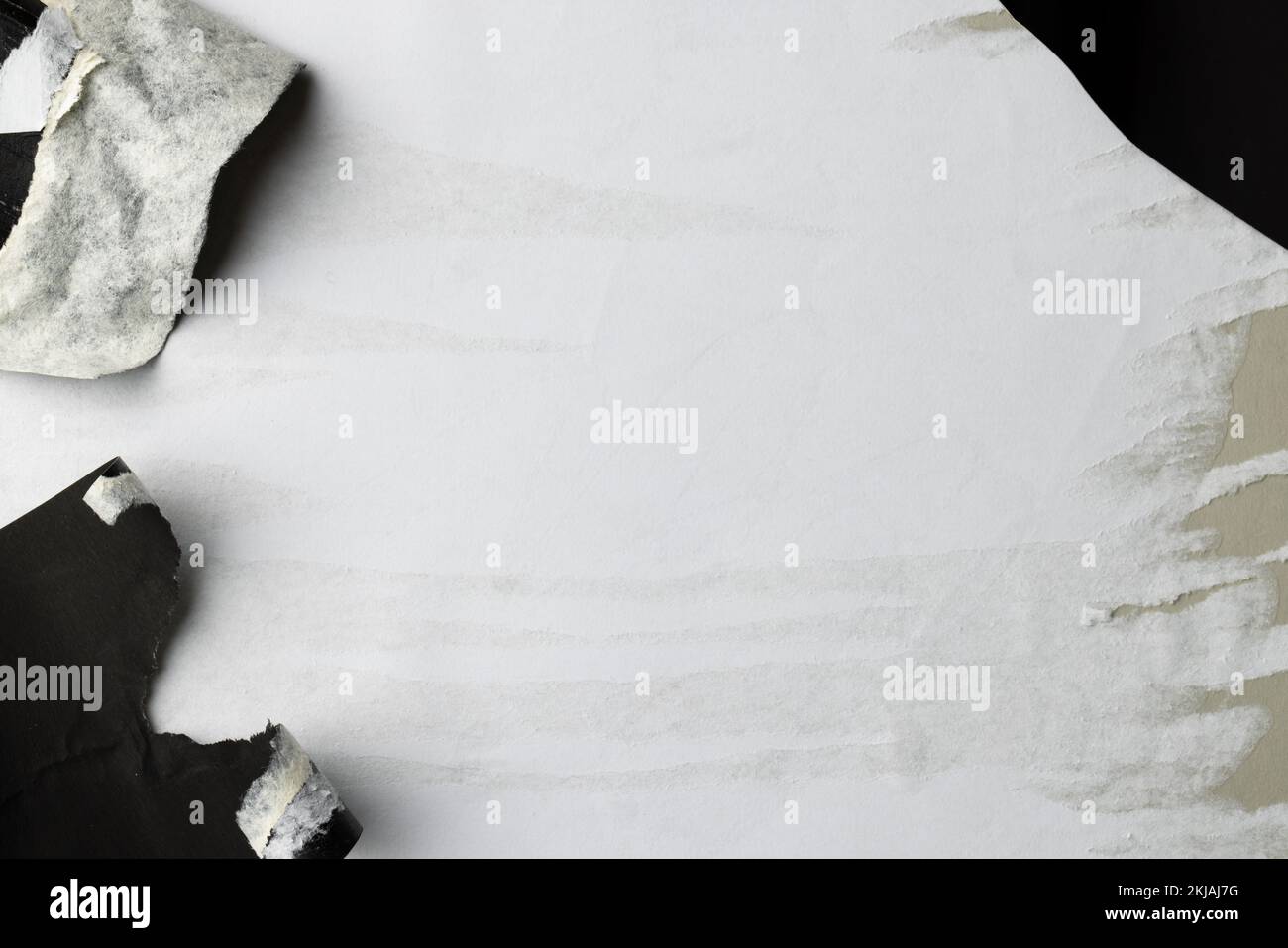 Ripped up pieces of white and black paper with copy space on gray ...