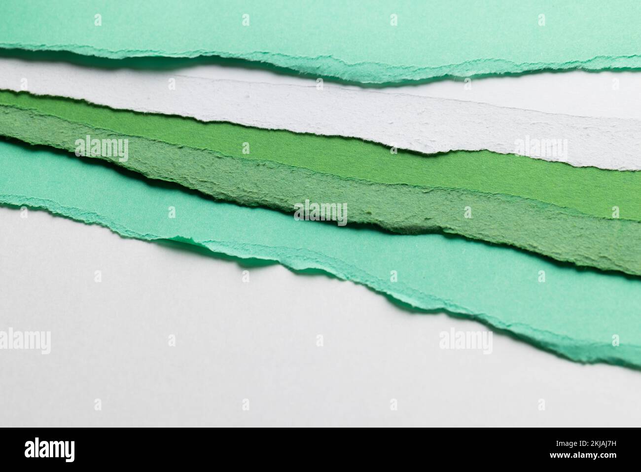 Ripped up pieces of coloured paper and copy space on white background ...