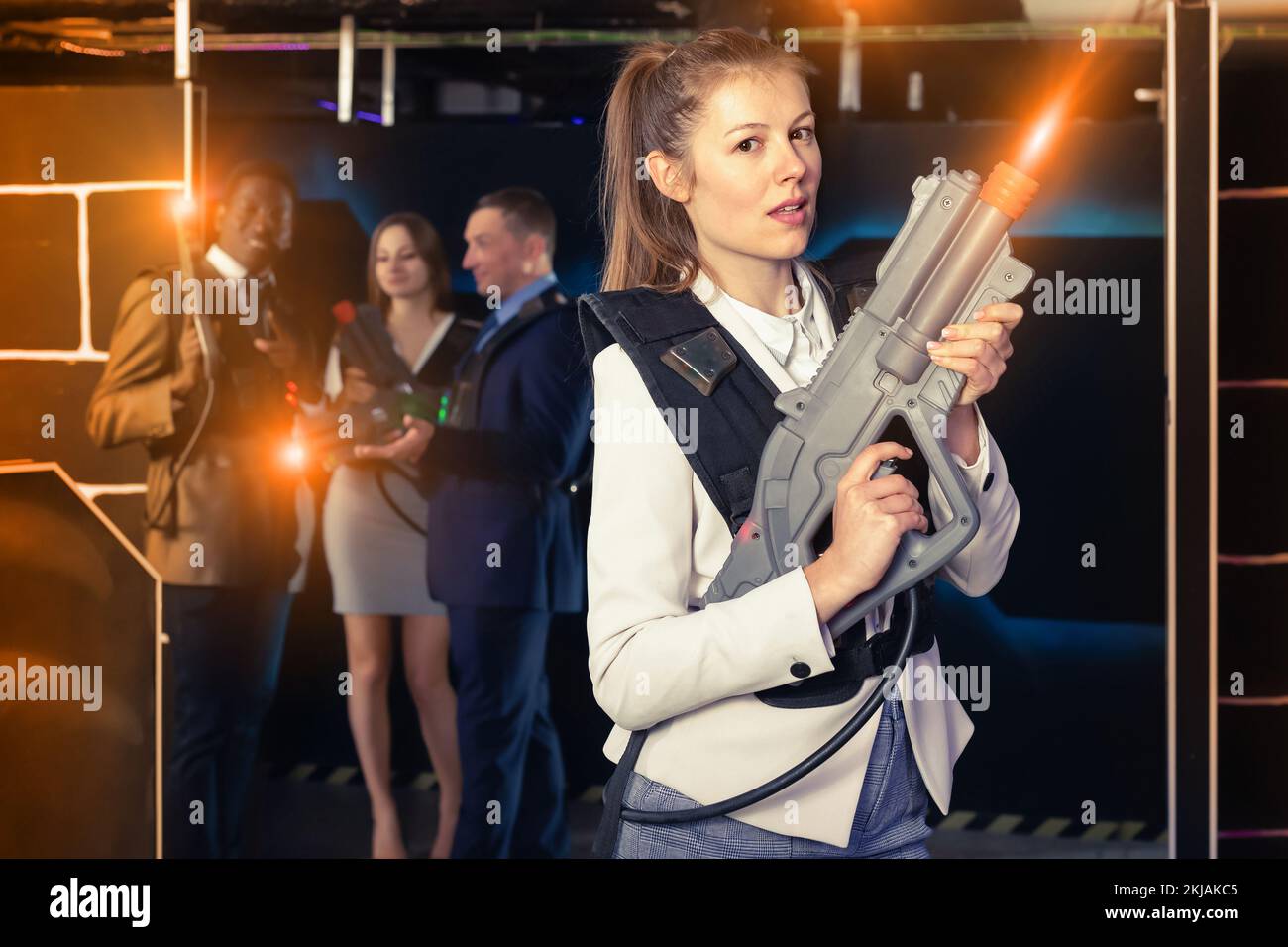 Nice female and her colleagues in laser tag room Stock Photo - Alamy