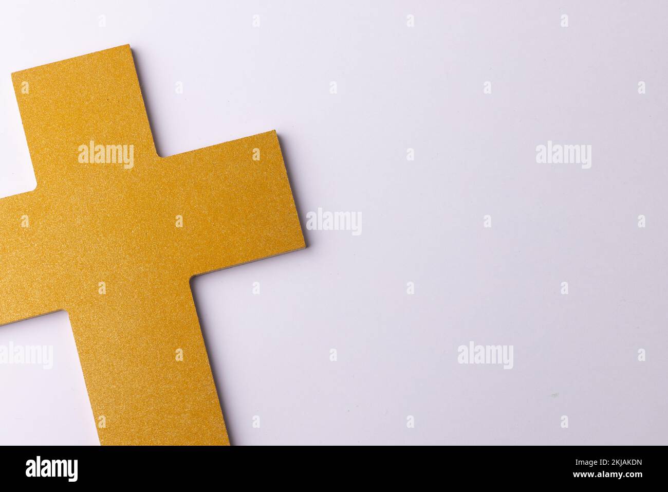 Overhead of yellow christian cross, on white background with copy space ...