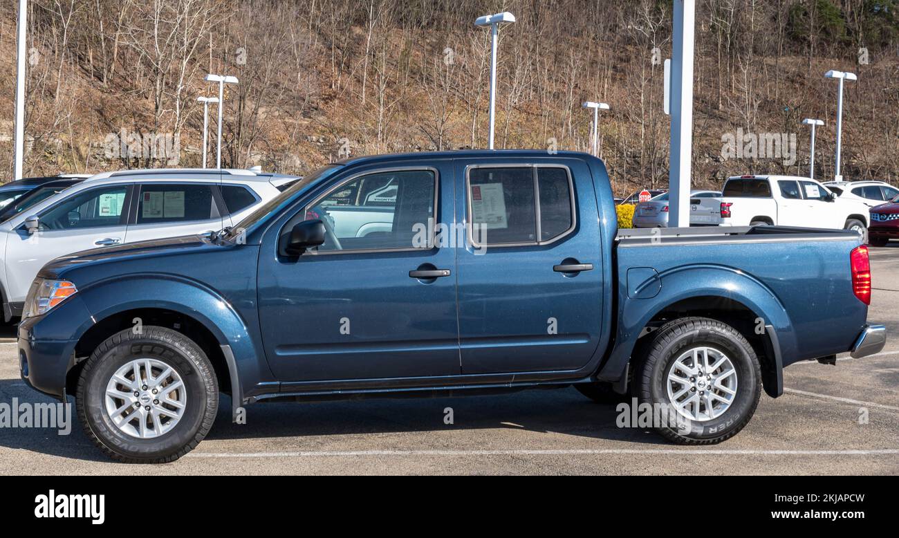 A new, blue four door Nissan Frontier pickup truck for sale at a ...