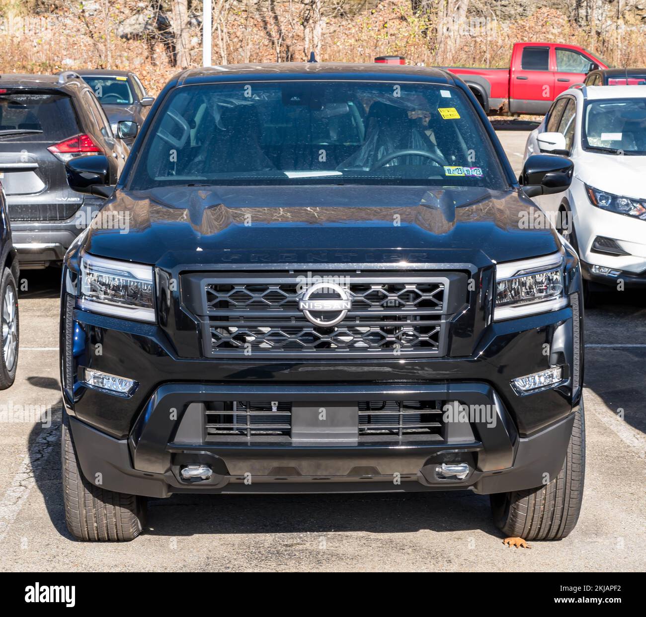 A new, black four door Nissan Frontier pickup truck for sale at a ...