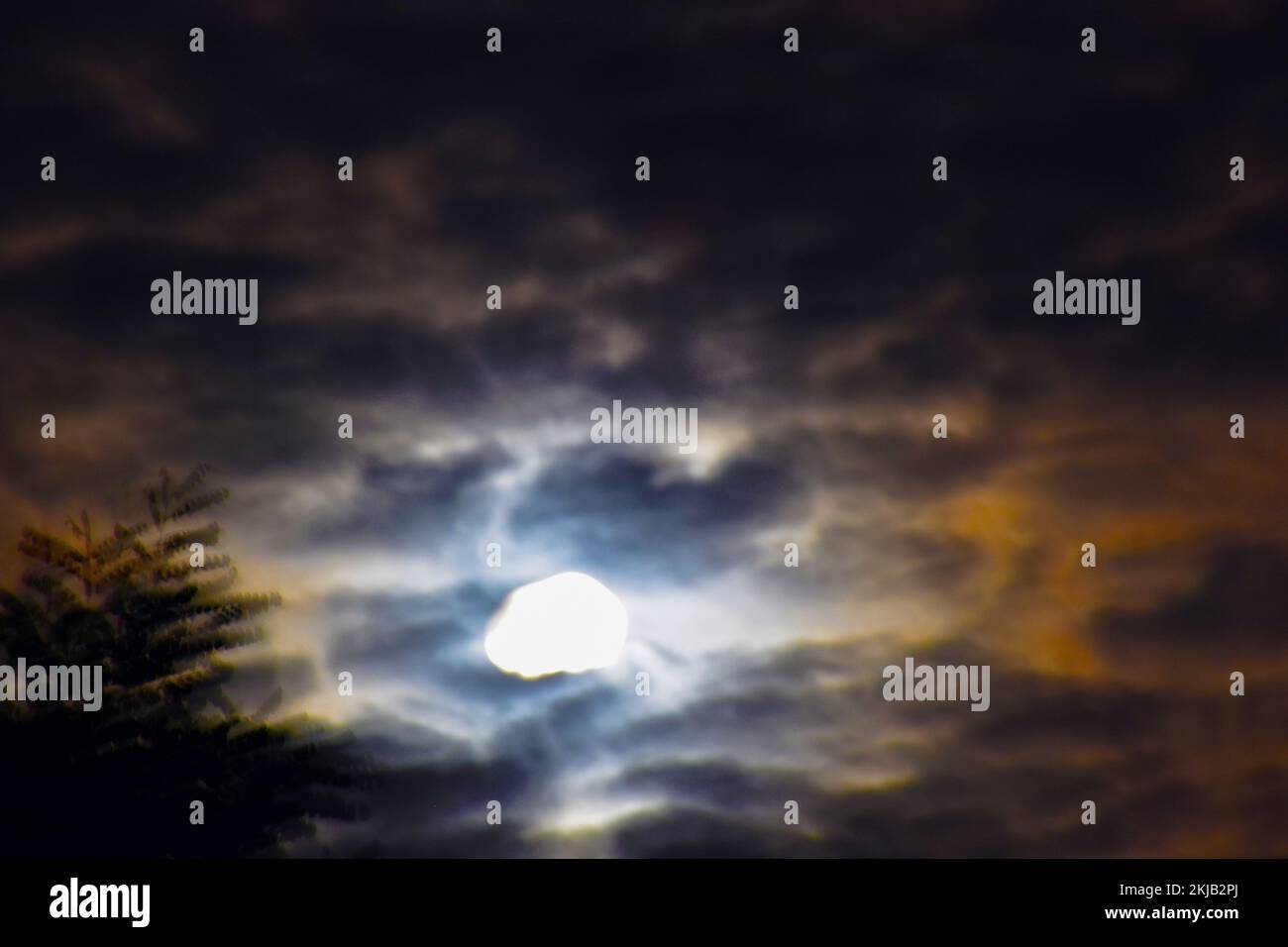 The deformed moon is covered by mysterious clouds of dark gray-brown ...