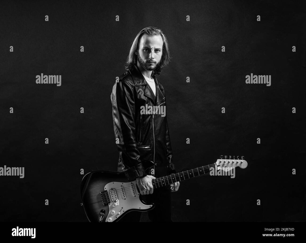 music festival. bearded rocker in leather jacket. man long hair play ...