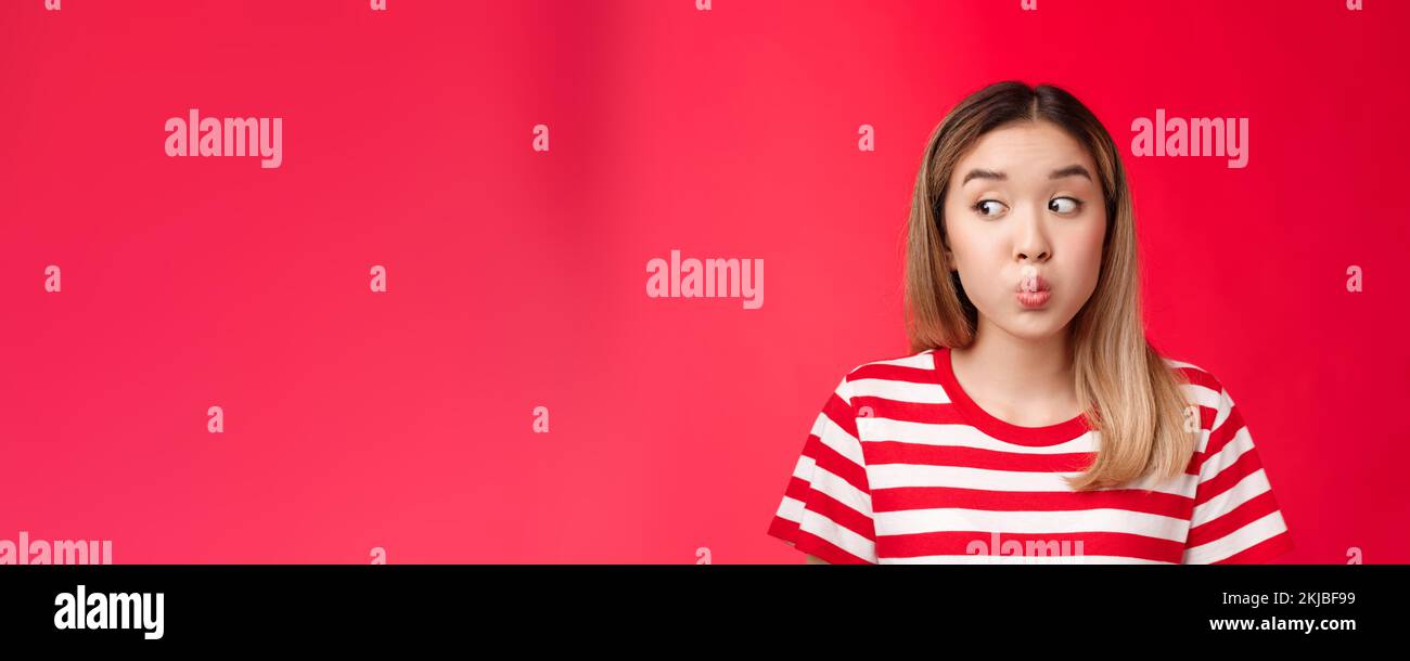 Close-up silly tender young modern asian girl blond haircut hold breath ...