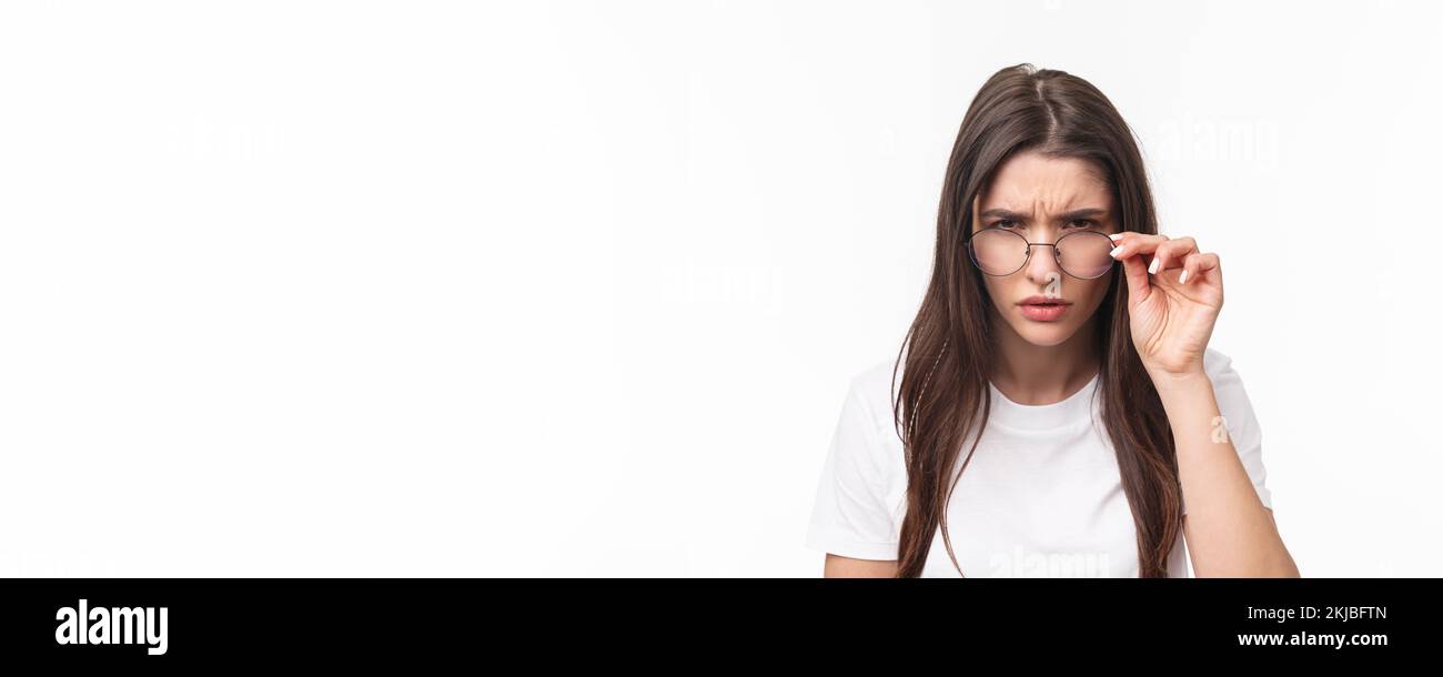 Close-up portrait of suspicious young serious-looking woman, look from ...