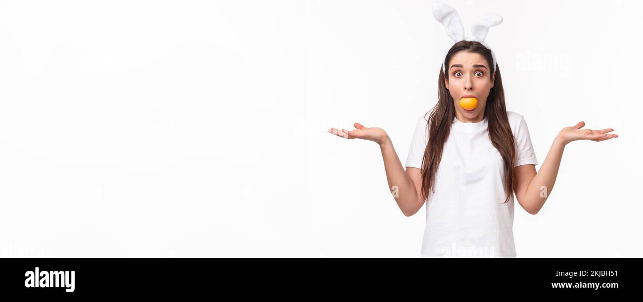 Portrait of confused and indeisive young funny woman with rabbit ears ...