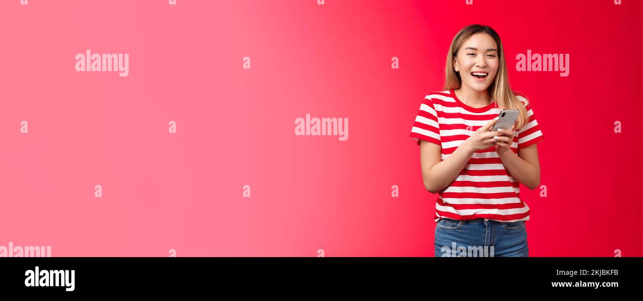 Happy cheerful asian blond girl laughing using smartphone, girl hold ...