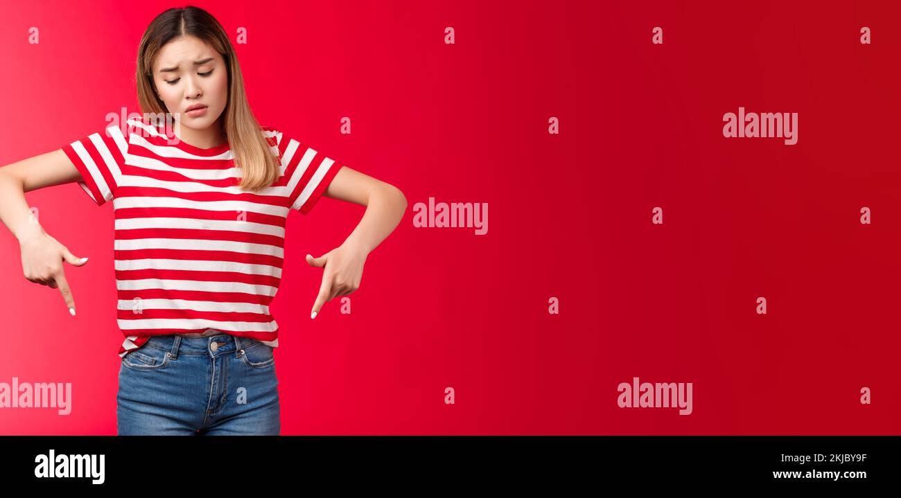 Disappointed gloomy blond asian girl sighing upset looking pointing ...