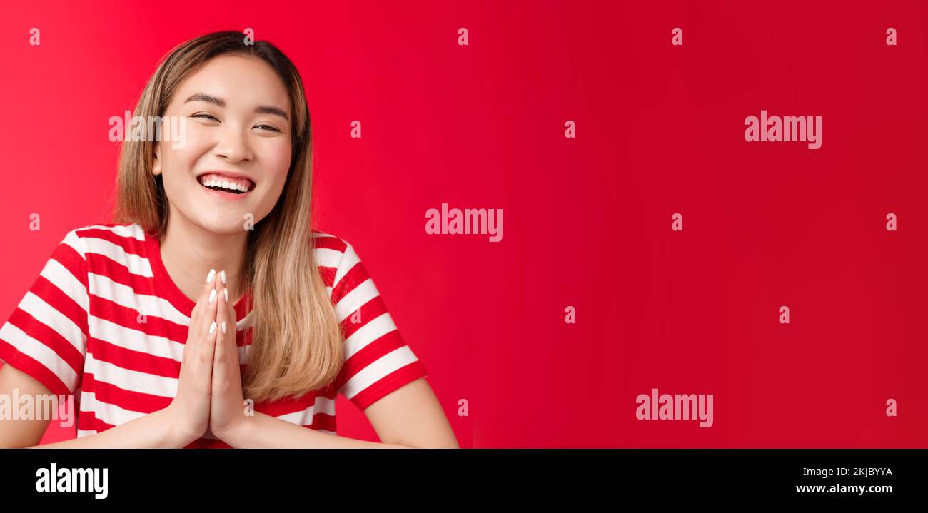 Close-up cheerful carefree laughing cute asian girl hold hands pray ...