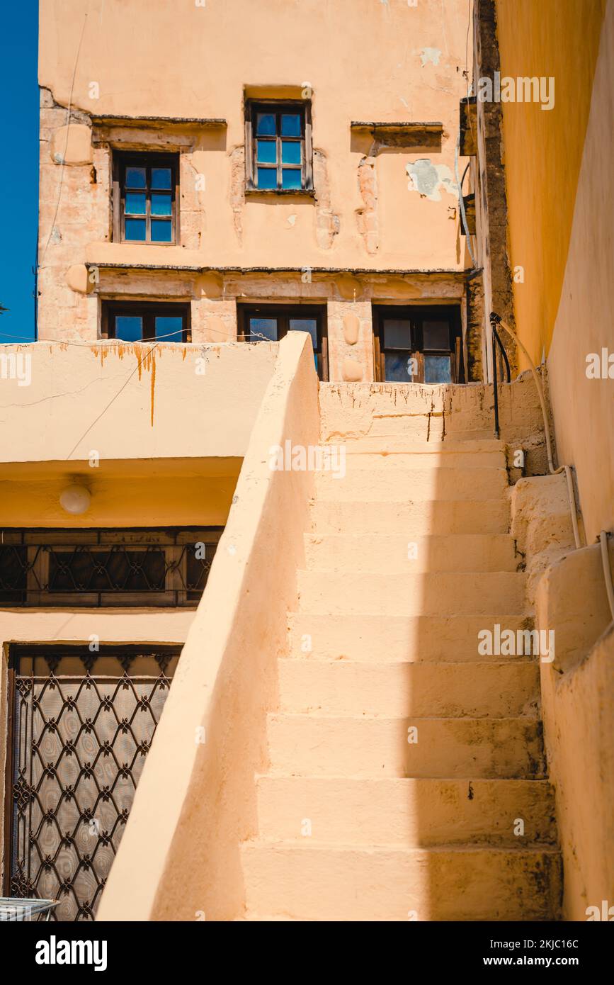 Yellow walls, yellow steps and blue glass of window in Greece Stock ...