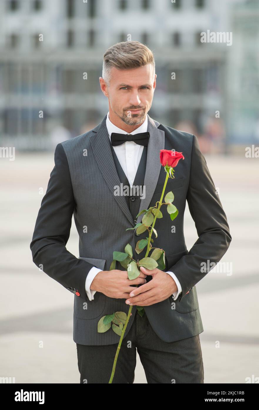 handsome man in tuxedo at romantic occasion. man with romantic present ...
