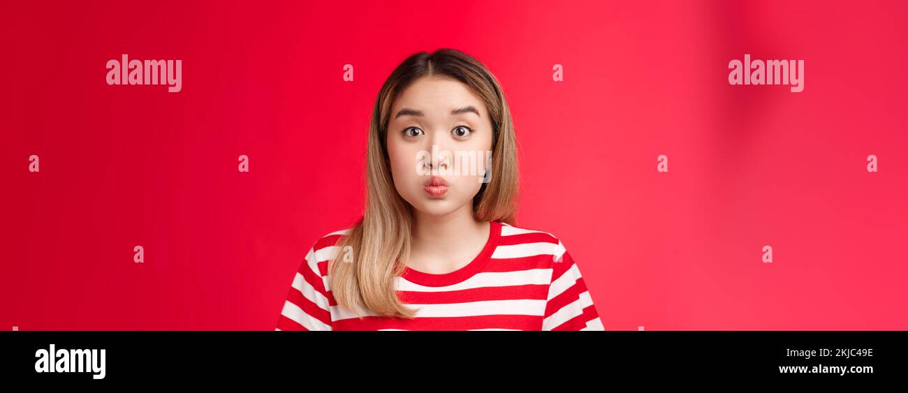 Close-up silly cute asian blond girl pouting making playful face, fold ...