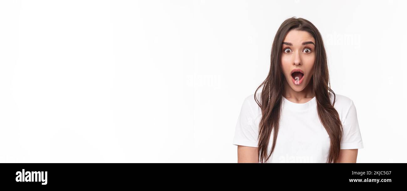 Close-up portrait of surprised and startled young brunette female drop ...