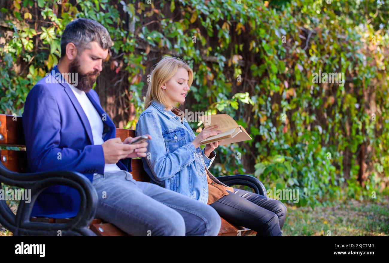 Woman read book while man read ebook smartphone. Man with beard and ...