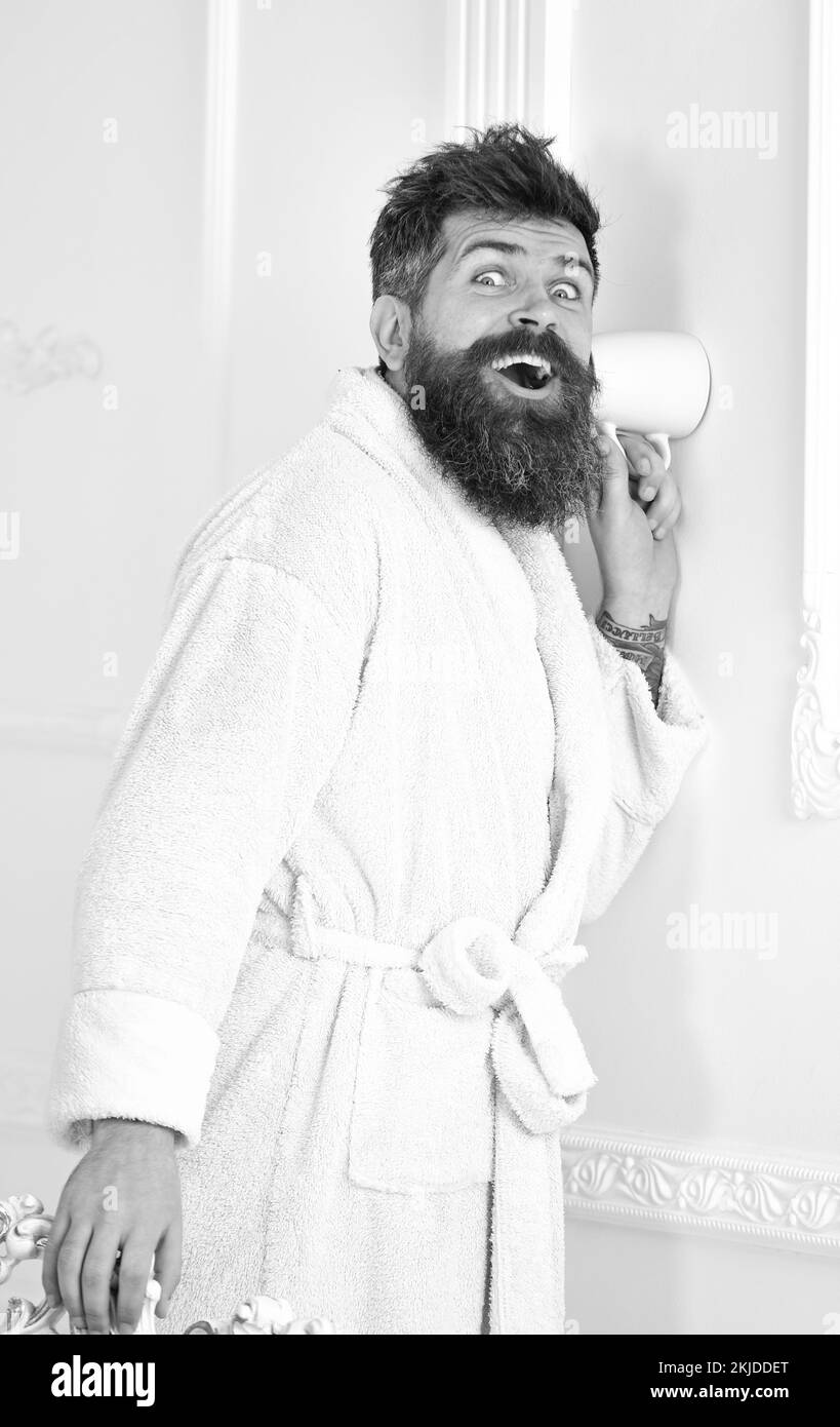 Hipster in bathrobe on surprised face secretly listen conversation ...