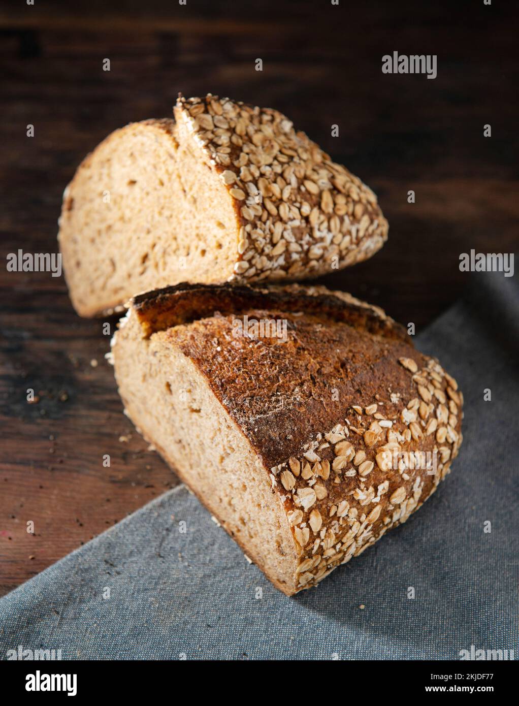 A vertical shot of sliced sourdough bread with whole-grain toppings ...