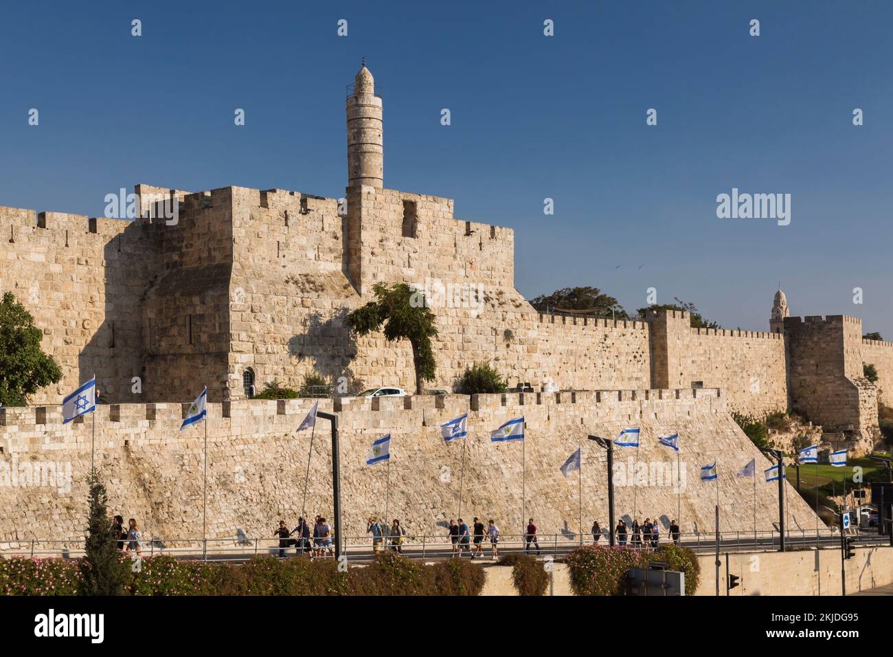 Tourists and local residents walking past the stone walls of the Old ...