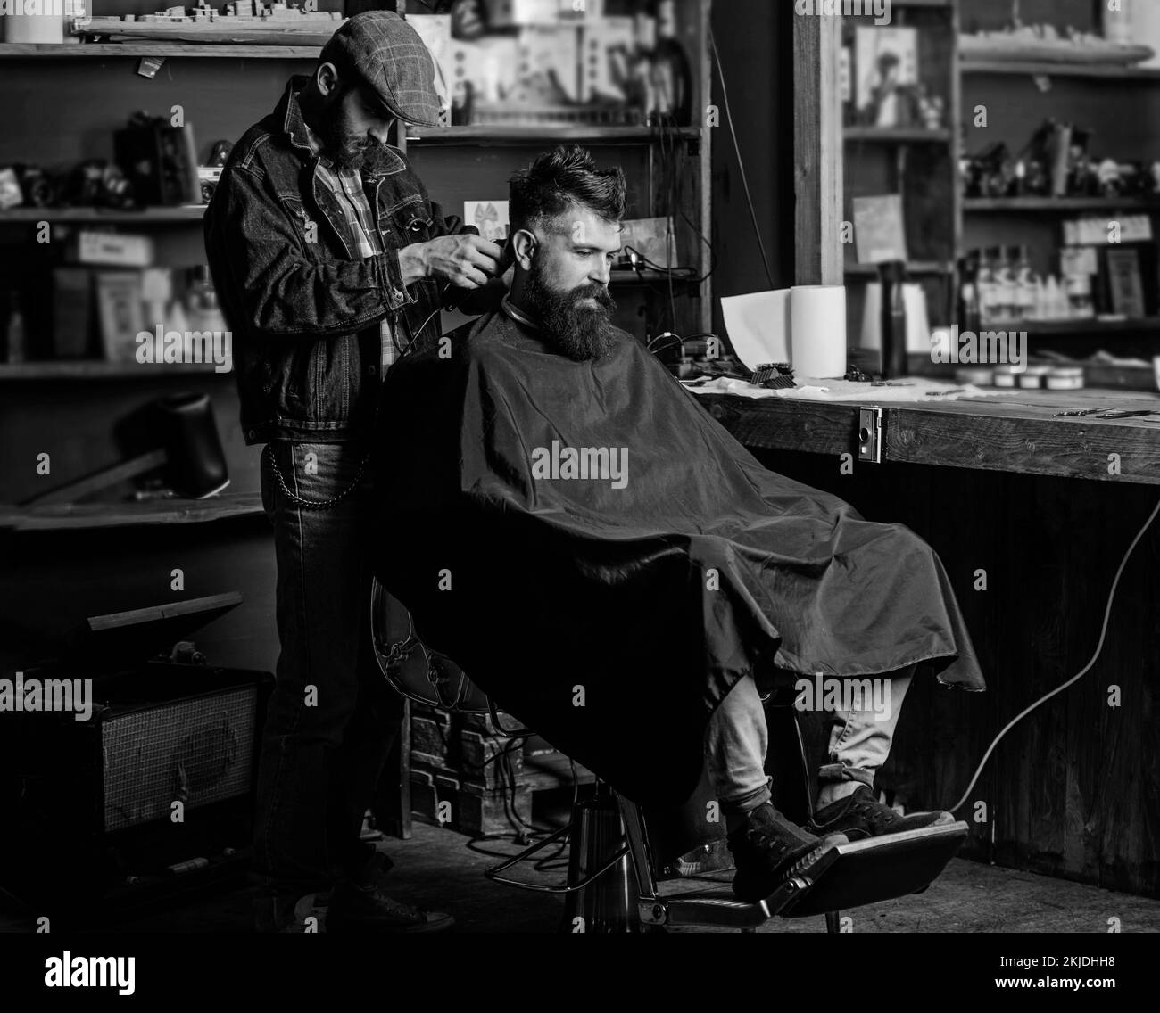Barber with clipper trimming hair on nape of client. Hipster client ...