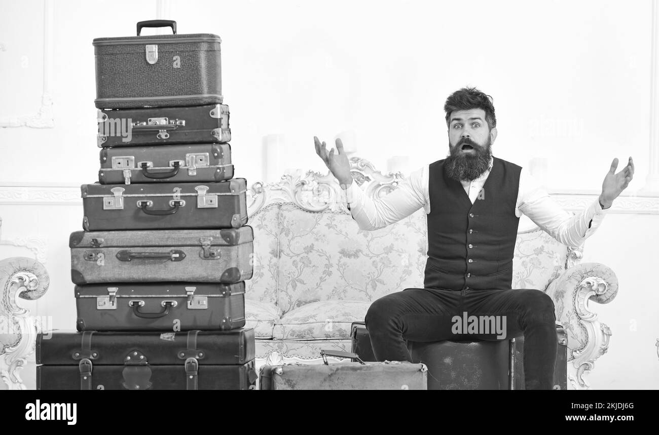 Man, butler with beard and mustache delivers luggage, luxury white ...