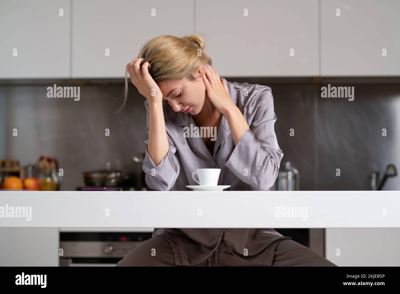 Sad woman in a kitchen. Depressed woman in the kitchen in the morning ...