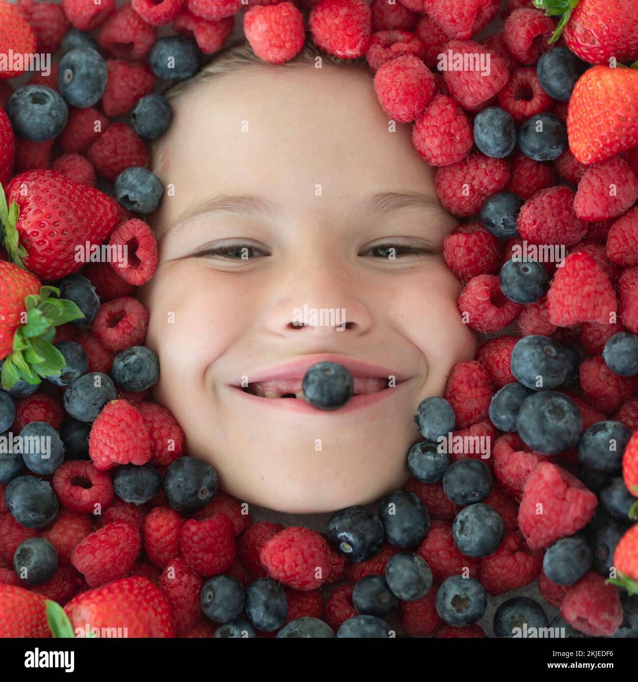 Berries child face close up. Top view photo of child face with berri ...