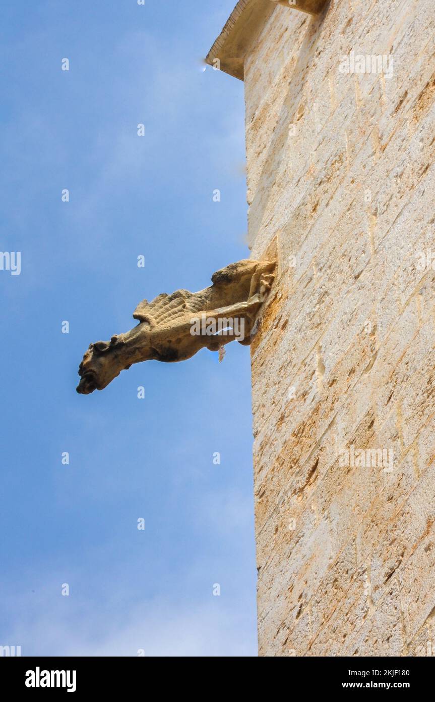 A vertical of a gargoyle on a wall against a blue sky Stock Photo - Alamy