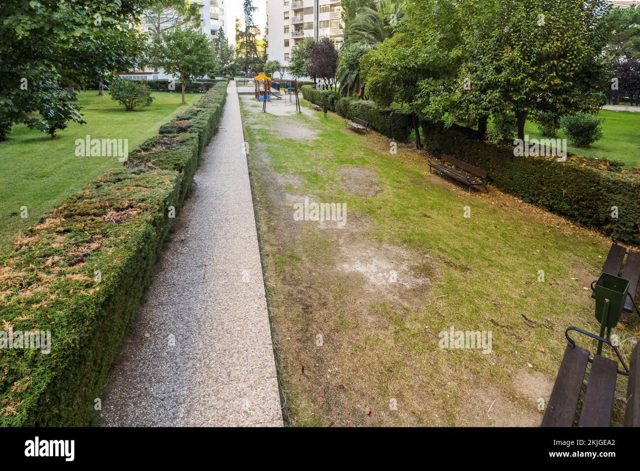 Gardens with hedges, trees and a children's playground in a communal ...