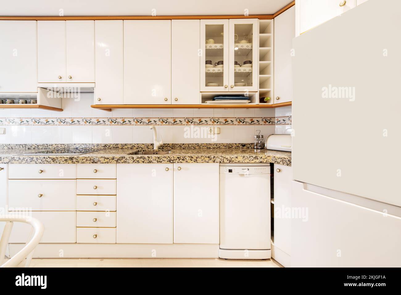 kitchen with white cabinets, pink granite countertops and white built ...