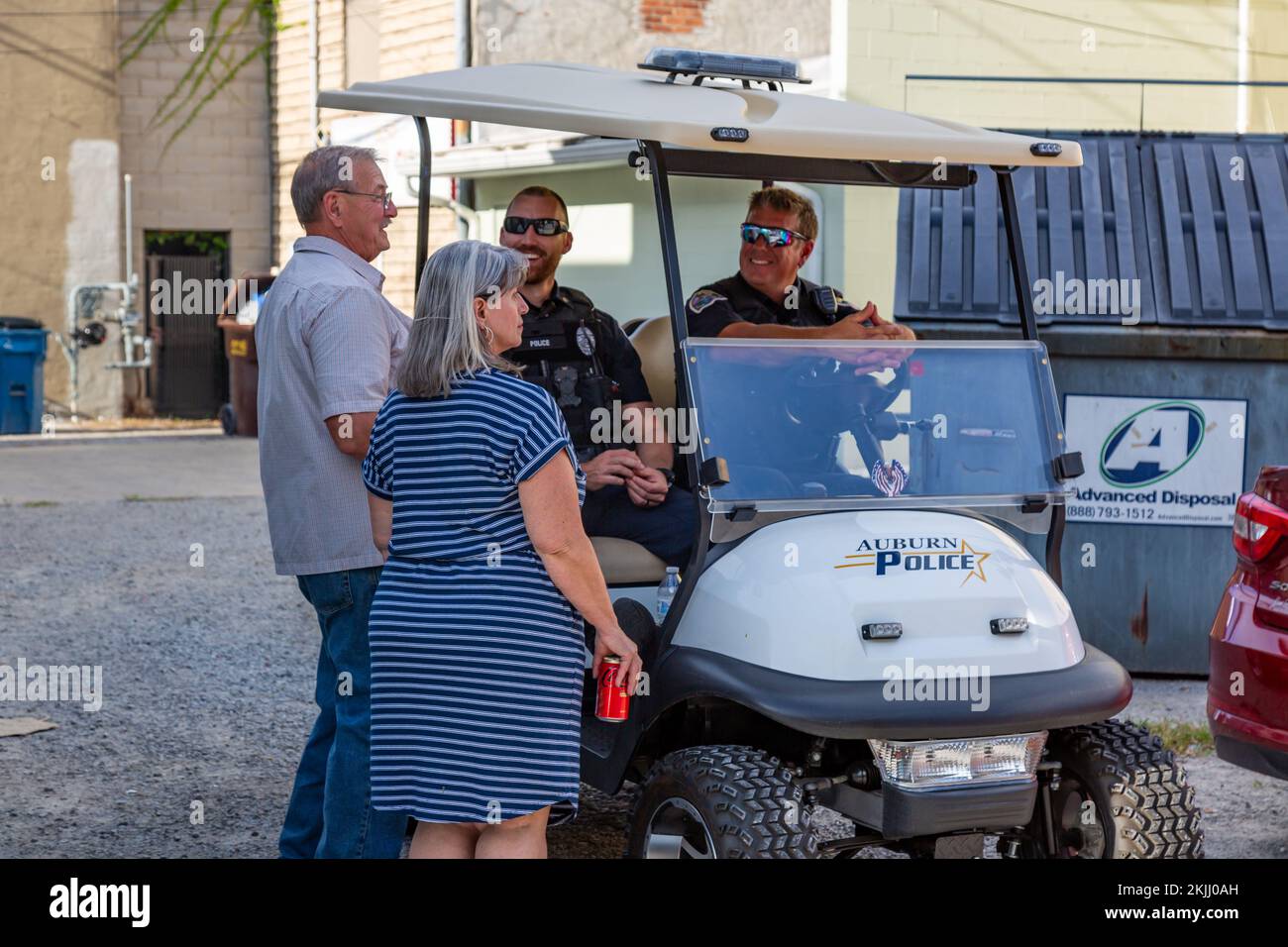 Officers of the Auburn Police Department sit in a marked Club Car golf ...