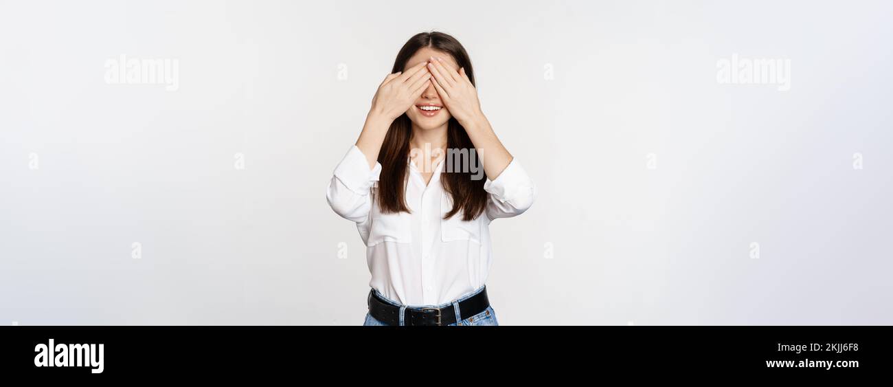 Smiling happy woman waiting for surprise, shut eyes with hands ...