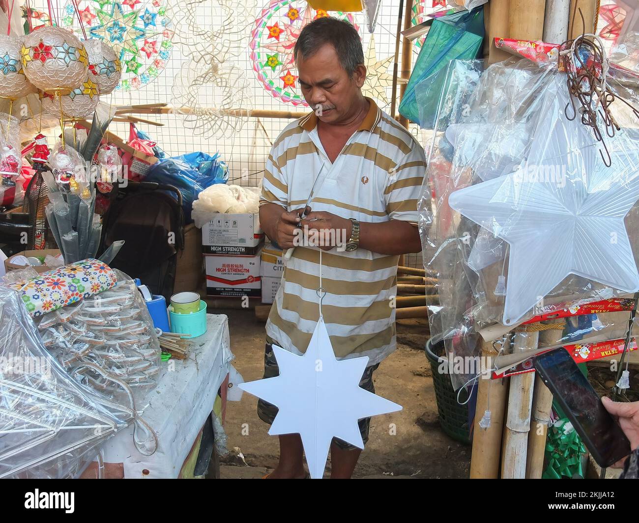 Jun San Martin, a parol maker seen cutting the thread of his ...