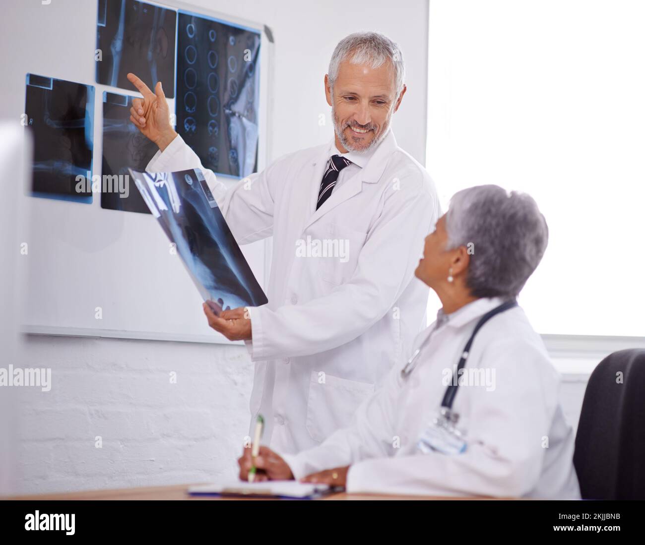 Consulting a colleague for a second opinion. two doctors working ...