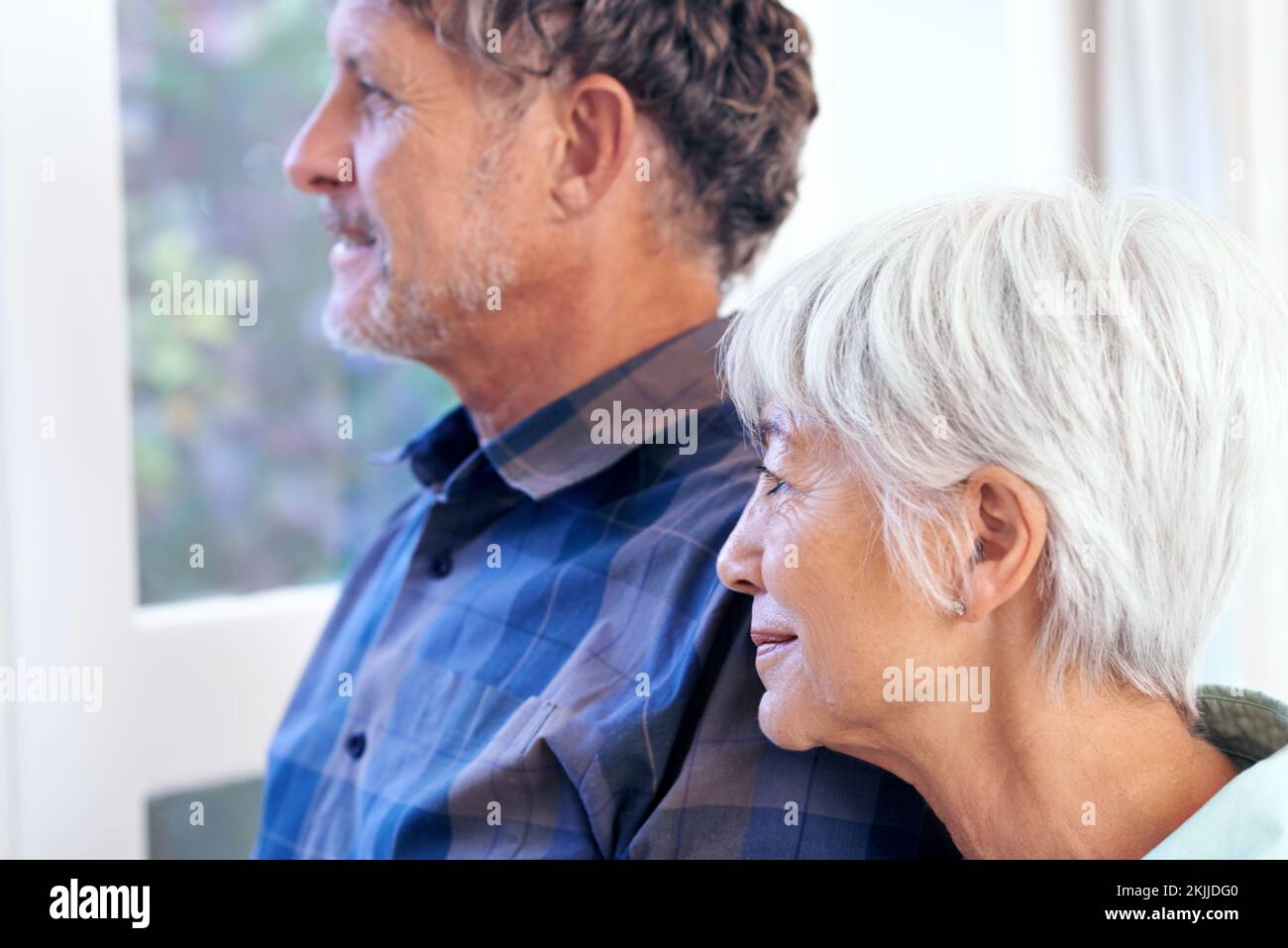 Getting through it all together. a happy senior couple looking out a ...