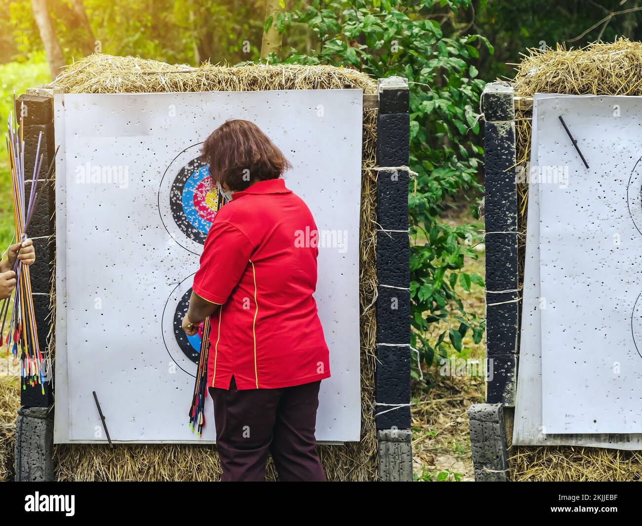 Back view of female officer wear face mask collect arrows fired from a ...