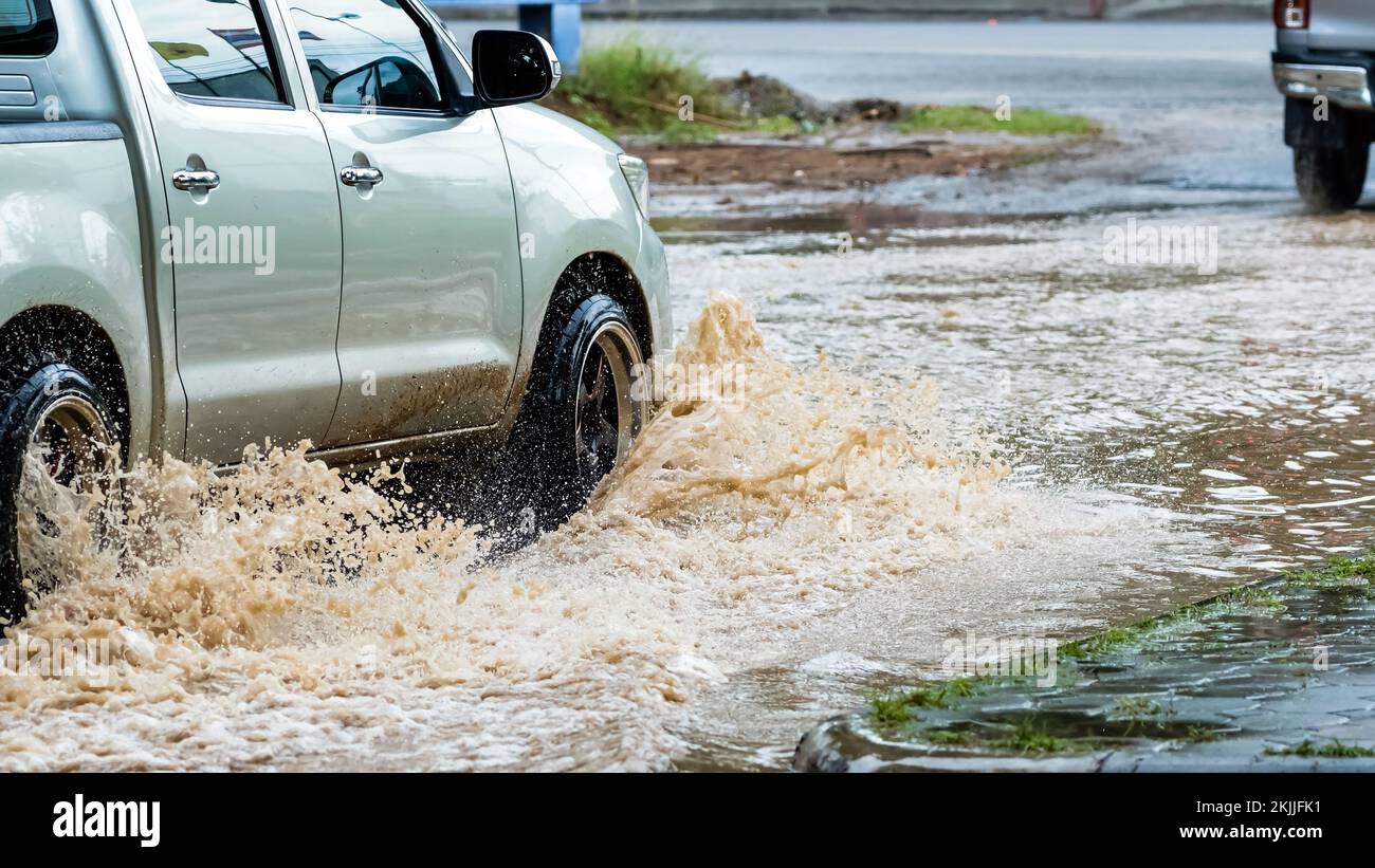 Pickup truck passing through flooded road. Driving car on flooded road ...