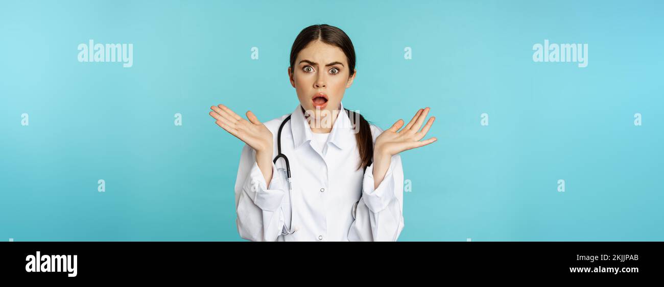 Portrait of shocked female doctor, worried healtcare worker in white ...