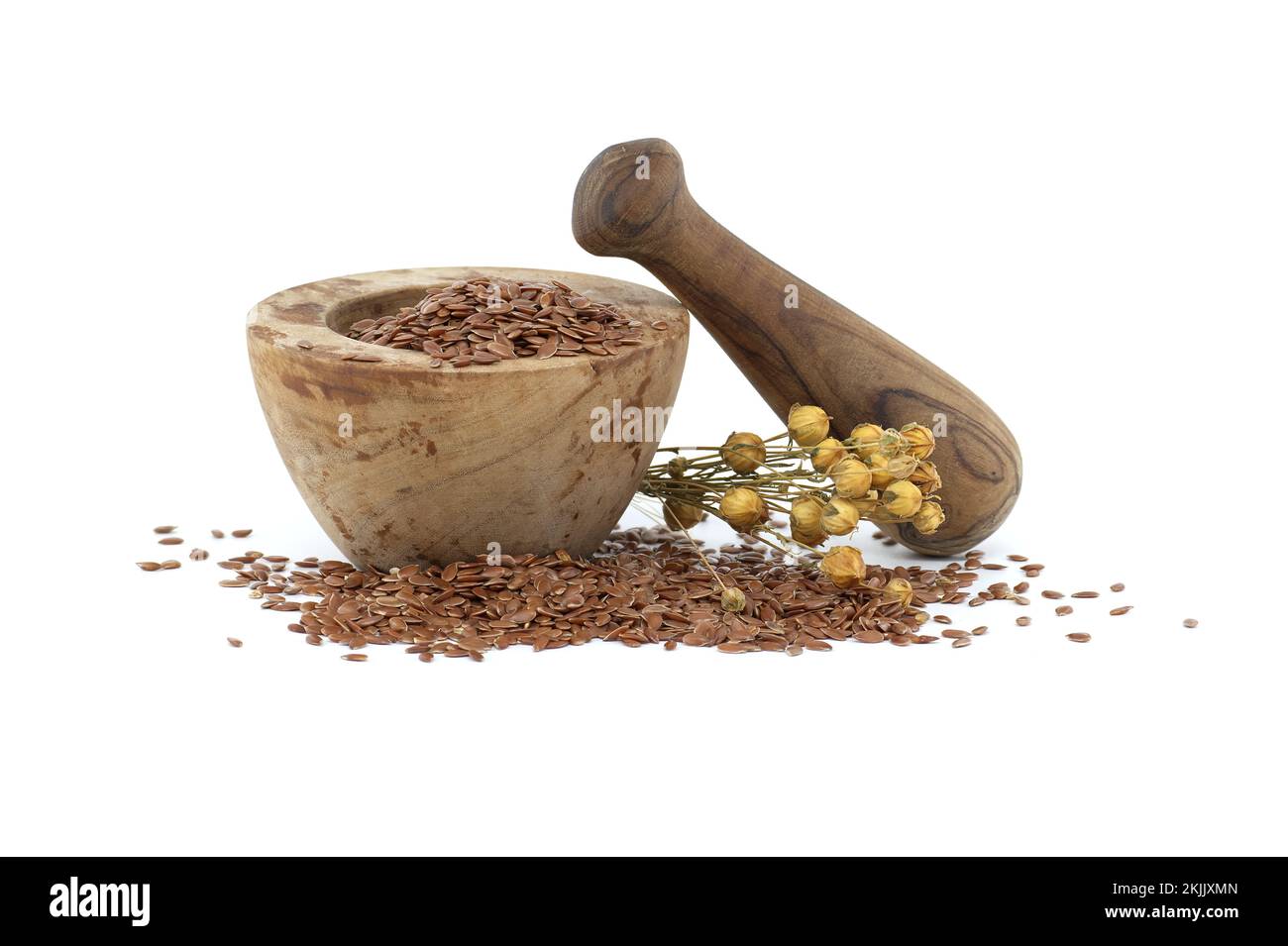 Linseed in wooden rustic-style mortar with pestle and bunch of flax plants isolated on white ...