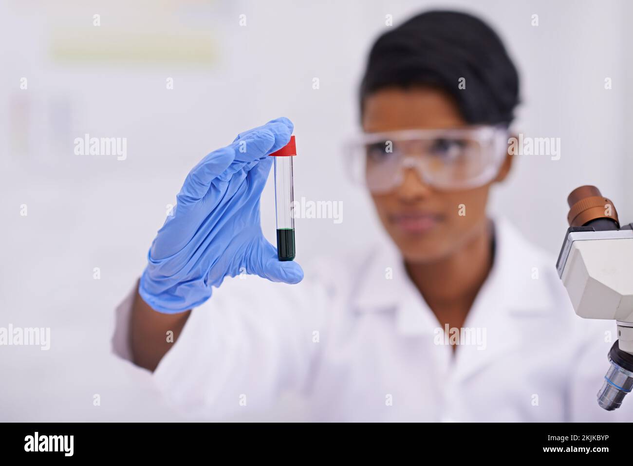 Perfecting the formula. A beautiful young scientist examining a test ...
