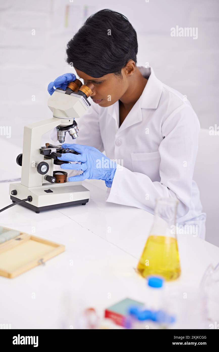 Careful and thorough observation. A young scientist using a microscope ...
